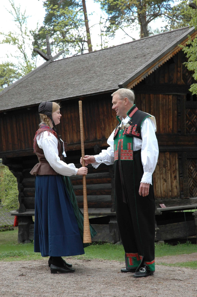 Jente og mann i drakt holder en neverlur mens de venter på at det ...