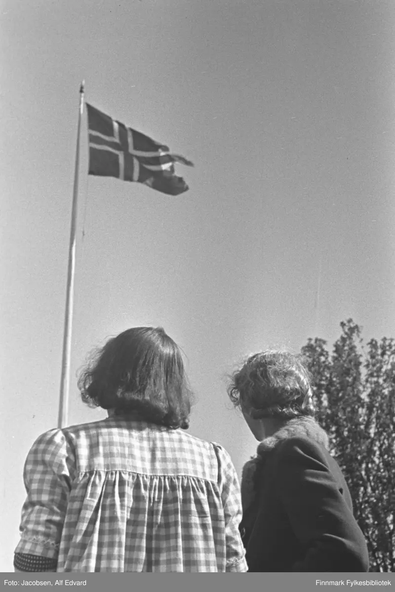 Aase og Ingeborg Jacobsen stående med ryggen til fotografen. De ser opp ...