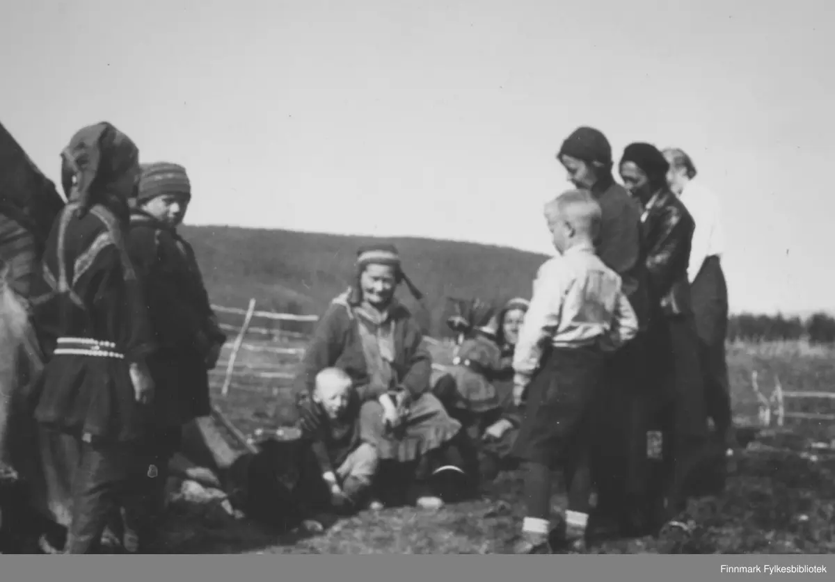 Sameleir nær Maze. En godt voksen dame i kofte og samelue holder armen ...