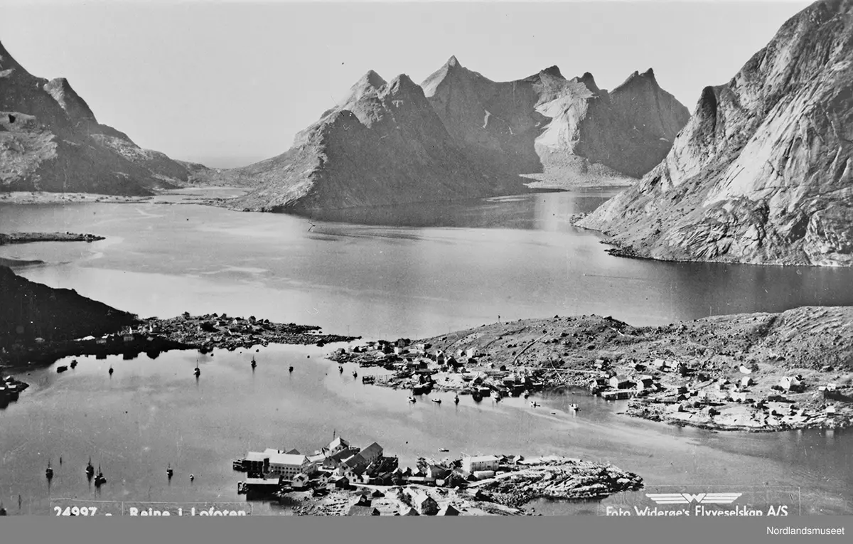 Reine i Lofoten. Flyfoto. Bygninger, fiskebåter på havna, havet og ...
