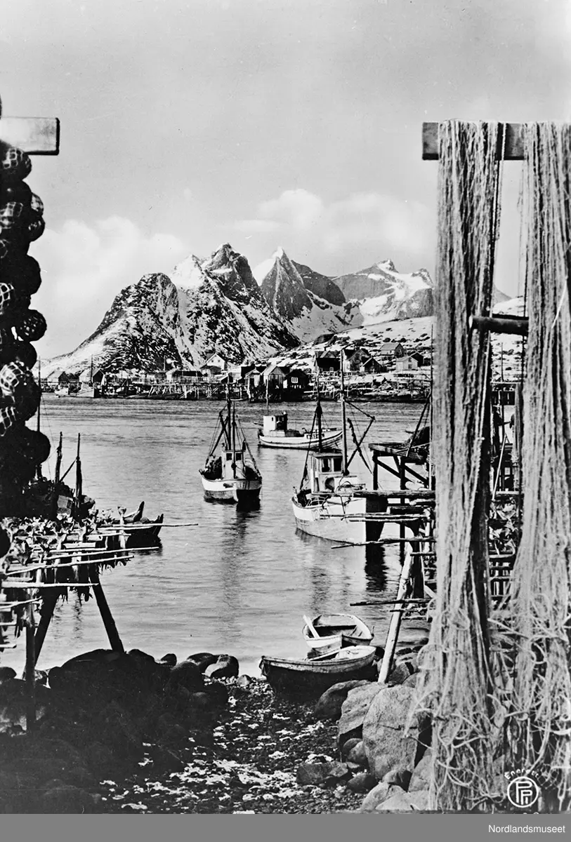 Reine i Lofoten. Hjell med garn til tørk helt i forgrunnen. Noen ...