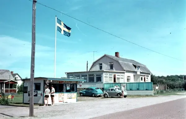 Kiosk vid Skummeslövsstrand med vajande flagga. Villa och bilar i ...