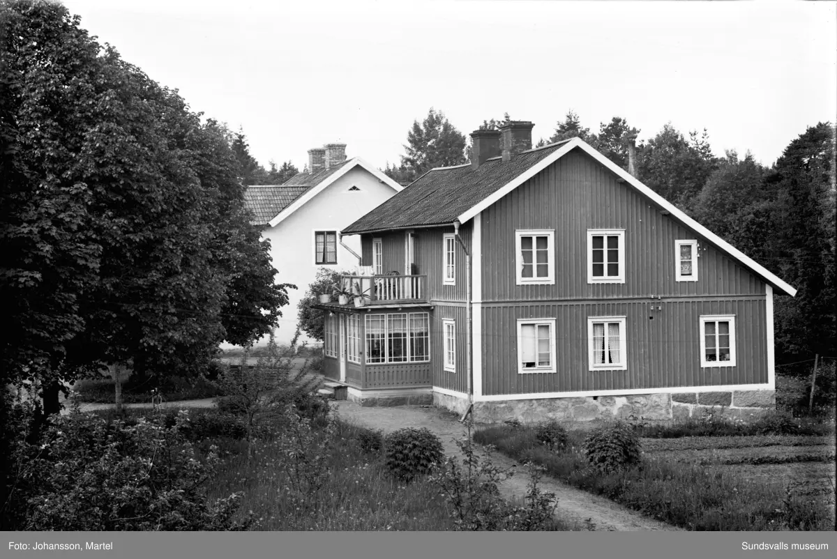 Bostadsbyggnad med glasveranda och balkong. Den ljusa byggnaden bakom ...