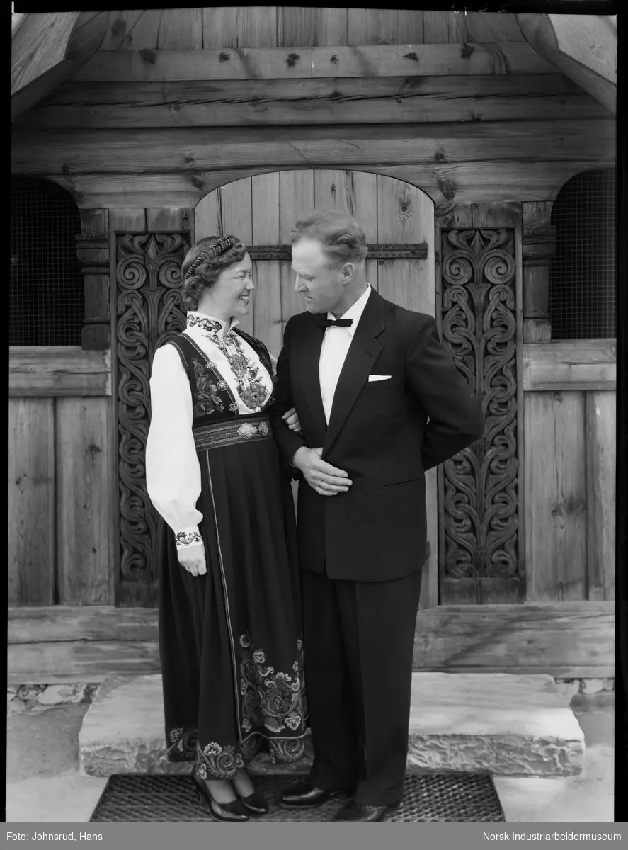 Brud i bunad og brudgom stående foran Heddal Stavkirke. - Norsk ...