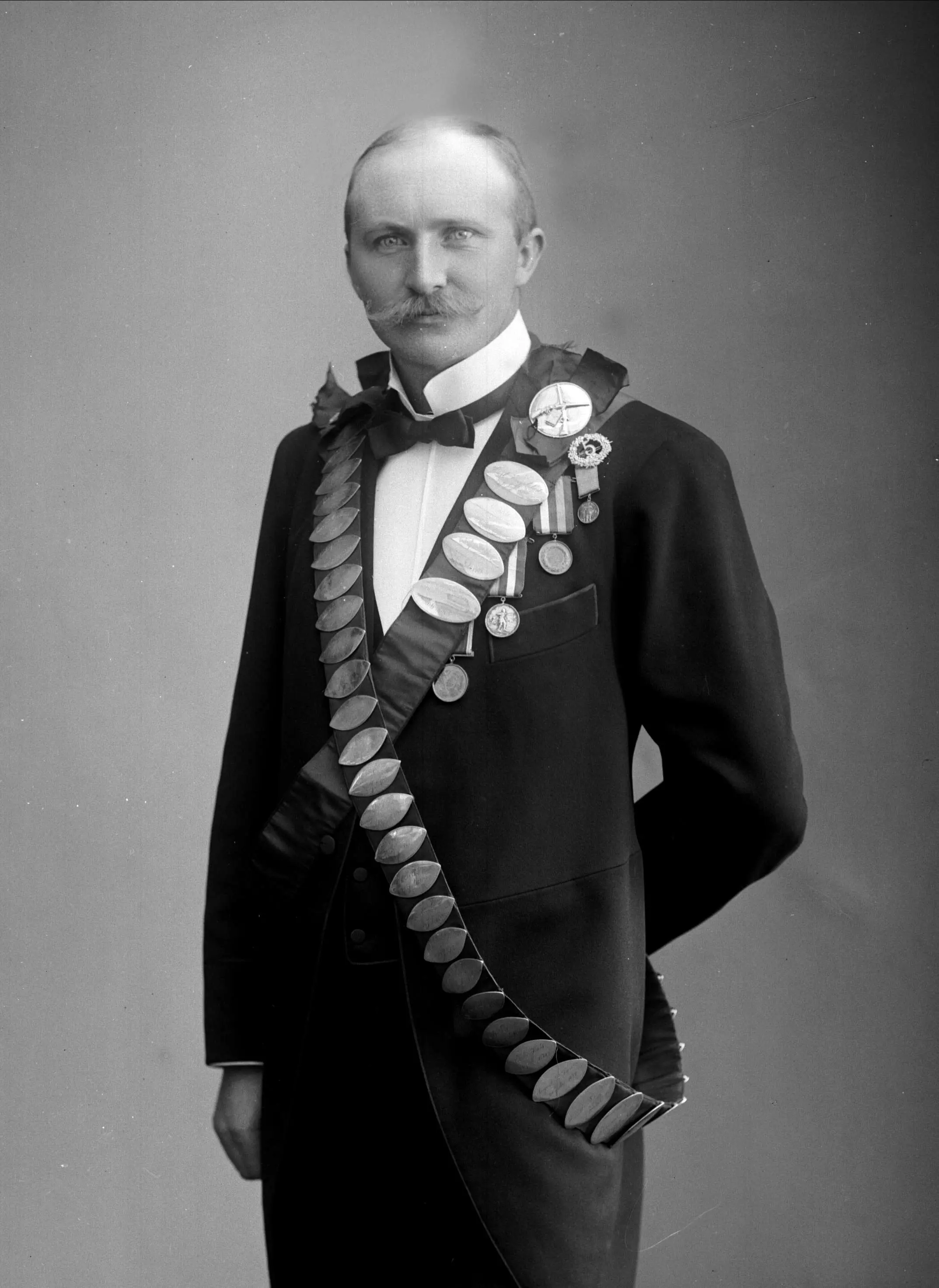 Portrett av Peder Olaf Olsen, antakelig. Bånd med premieplaketter fra ...