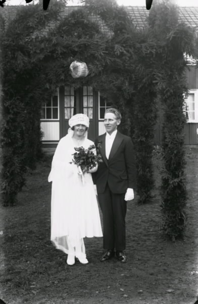 Bröllpsfoto av fotografens bror Ragnar Bengtsson med hustru framför en ...