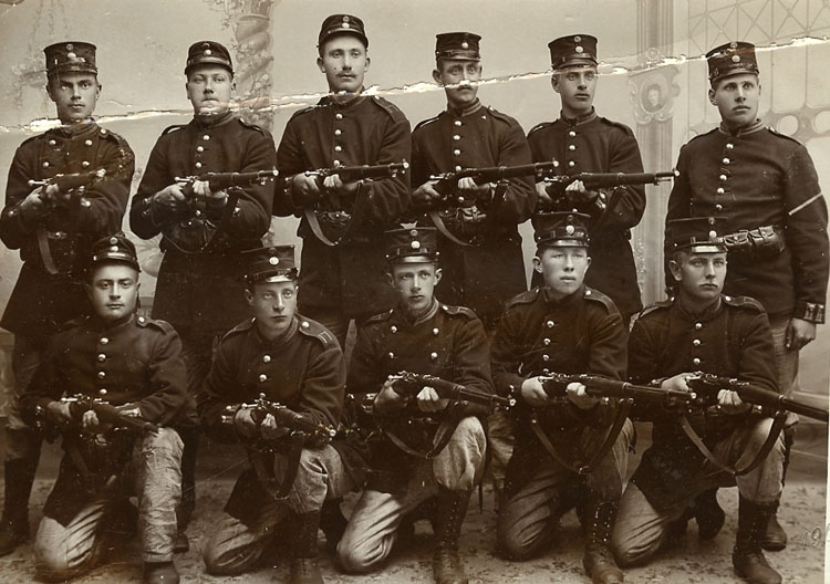 Enligt Bengt Lundins noteringar: "Ateljefoto av tio man med gevär och ...