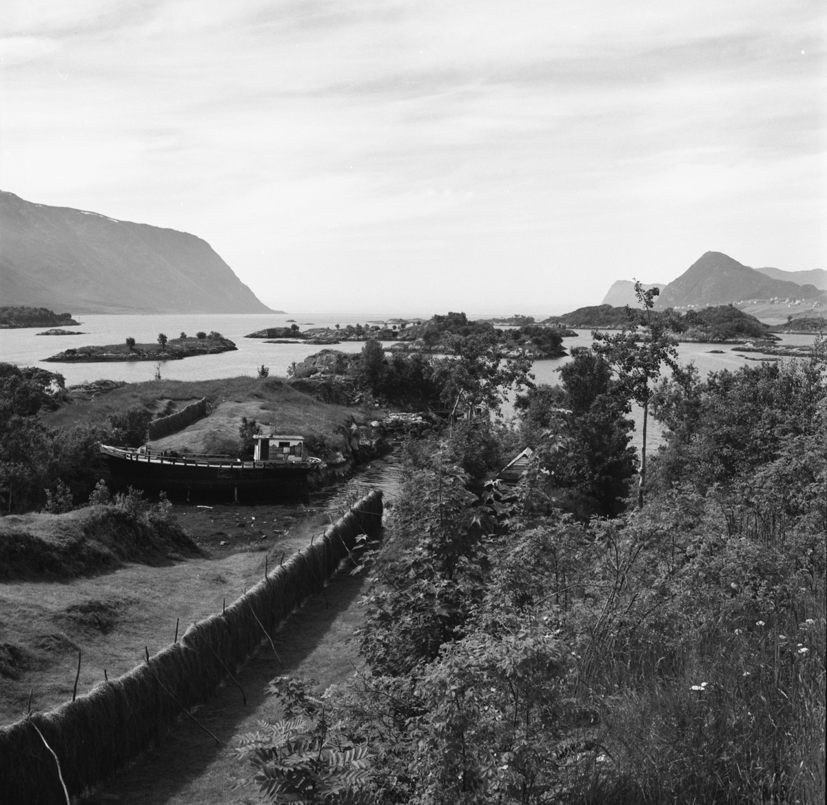 Prospektfotografi av et hesjegjerde og en båt i slipp i Kippervik ...