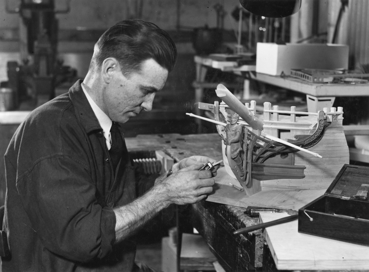 Sjöhistoriska museets modellverkstad. Modellbyggare Voldemar Konga arbetar på en stävmodell ...